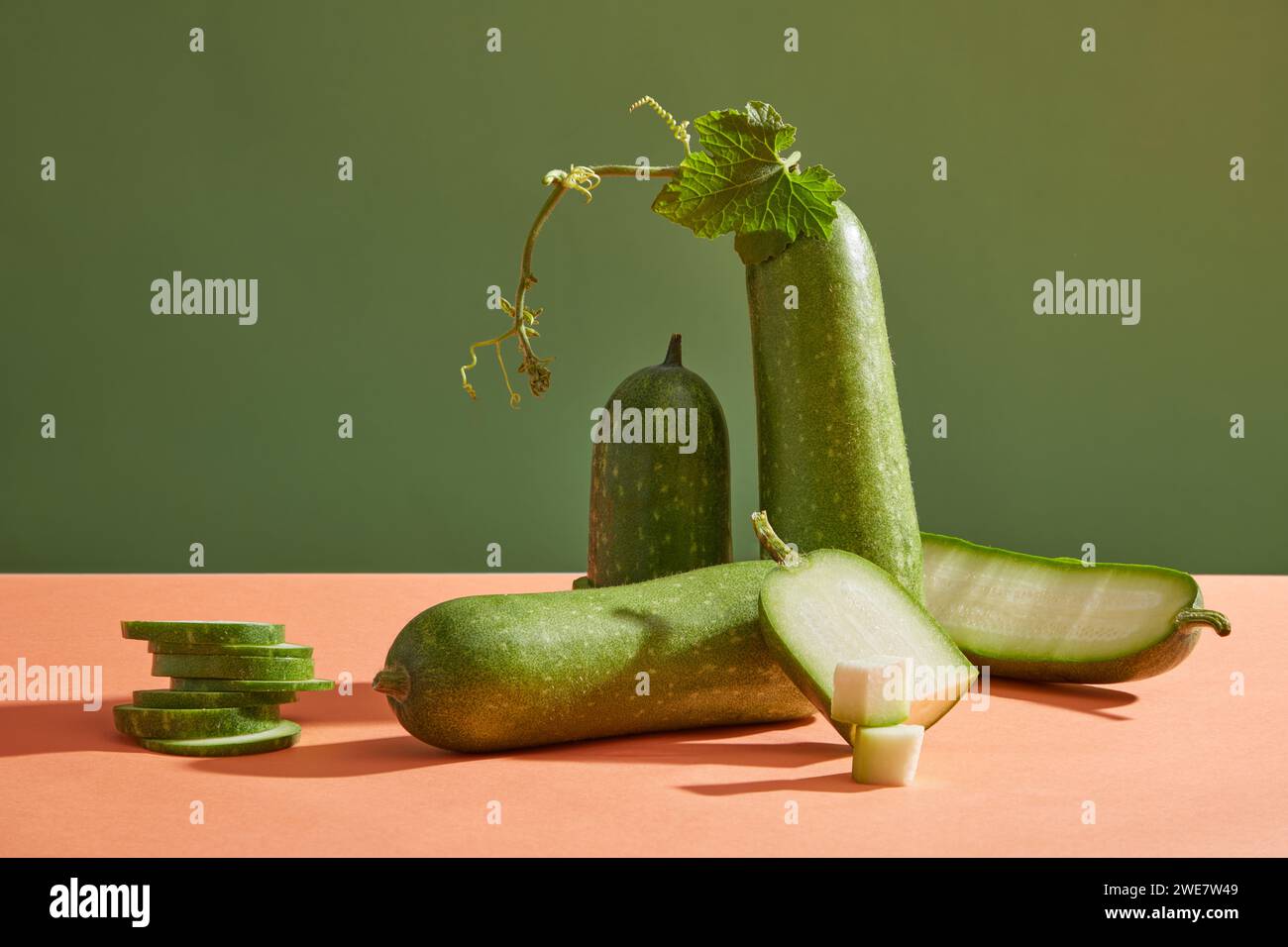 Fresh winter melon and some round slices stacked on each other over a ...