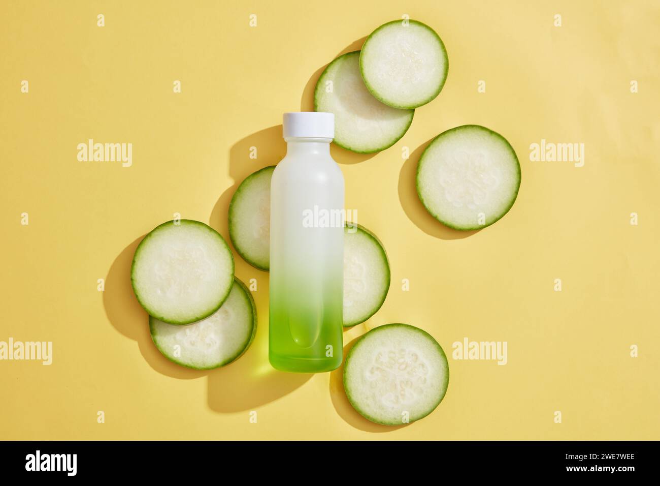 Unlabeled bottle in gradient green color put on some winter melon ...