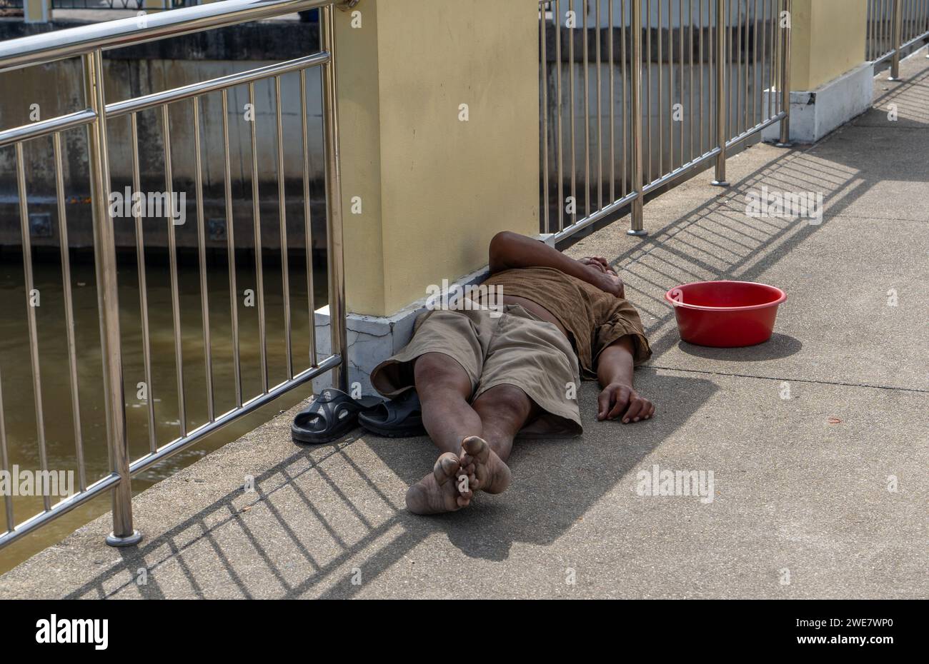 Homeless man sleeping on a bridge in Bangkok, Thailand Stock Photo - Alamy