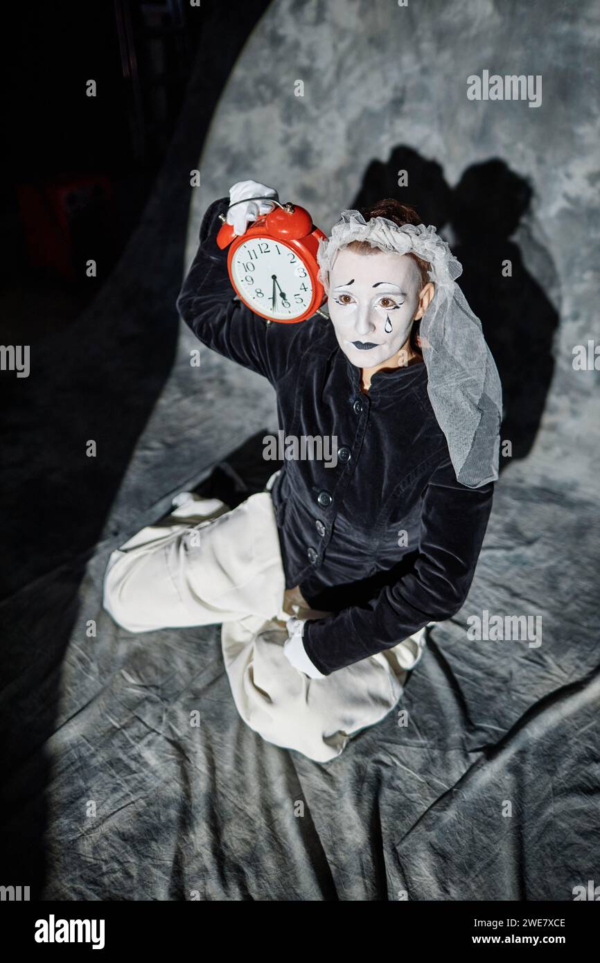 Vertical full length portrait of female mime artist performing act on ...