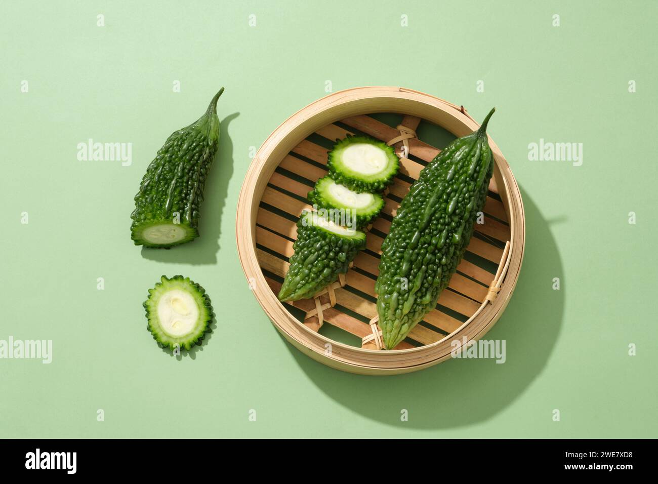 Bitter melon cut in slices placed inside a bamboo steam. Top view ...