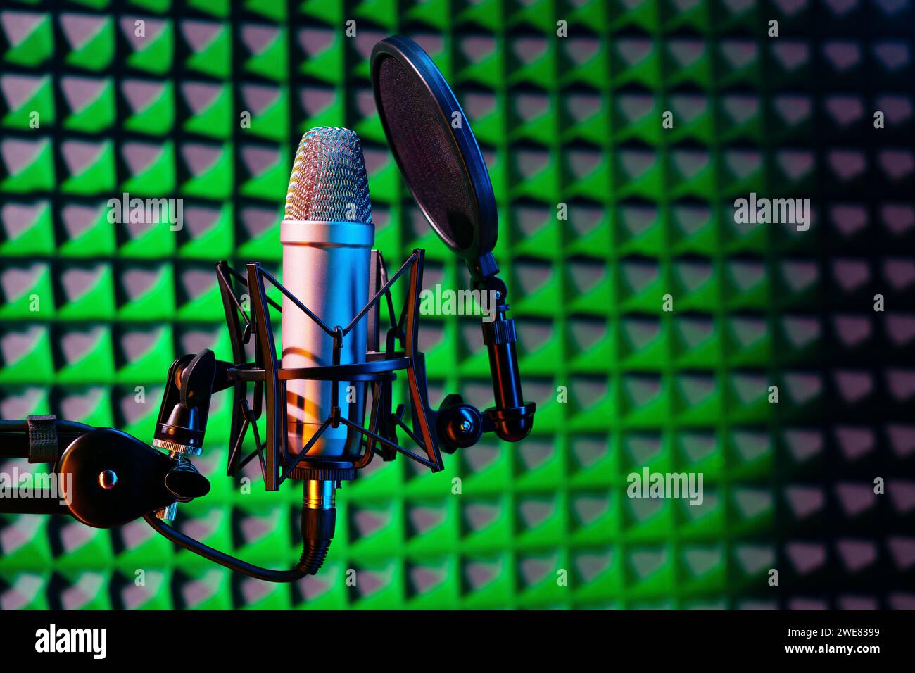 Professional studio microphone against acoustic foam panel background ...