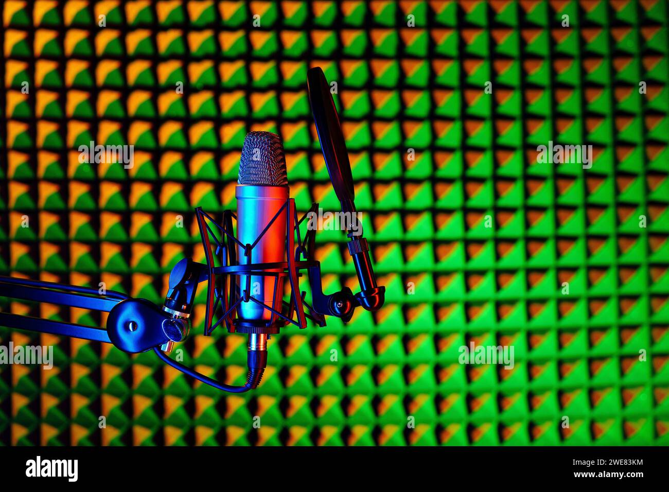 Professional studio microphone against acoustic foam panel background ...