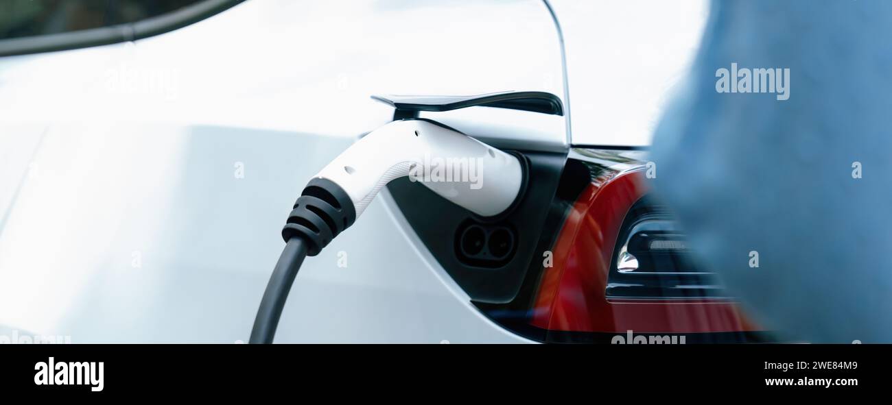 Panorama closeup EV charger handle plugged in or connect to electric ...