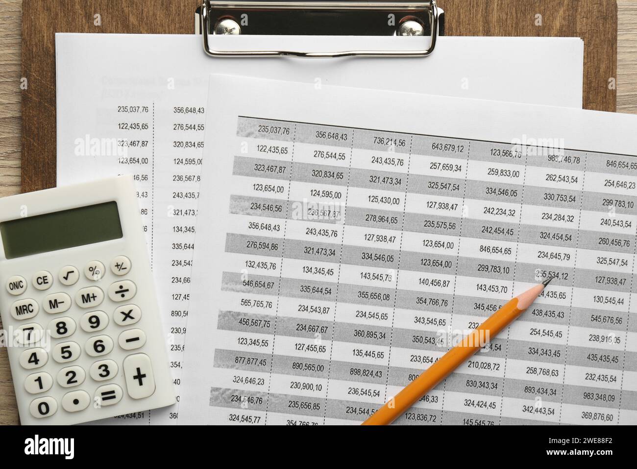 Accounting documents, calculator, clipboard and pencil on table, top ...