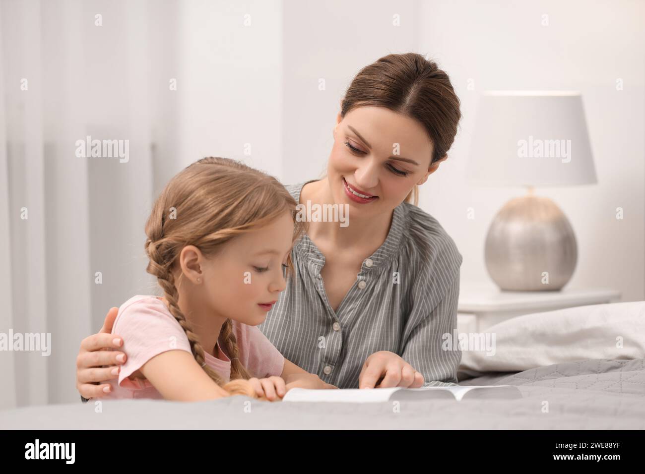Girl and her godparent reading Bible together at home Stock Photo - Alamy