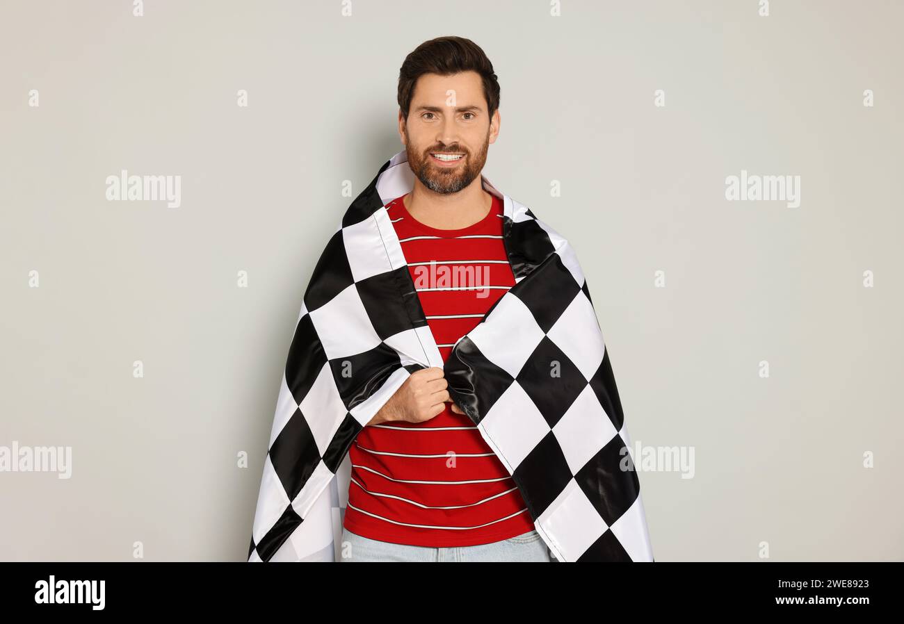 Man with checkered flag on white background Stock Photo - Alamy