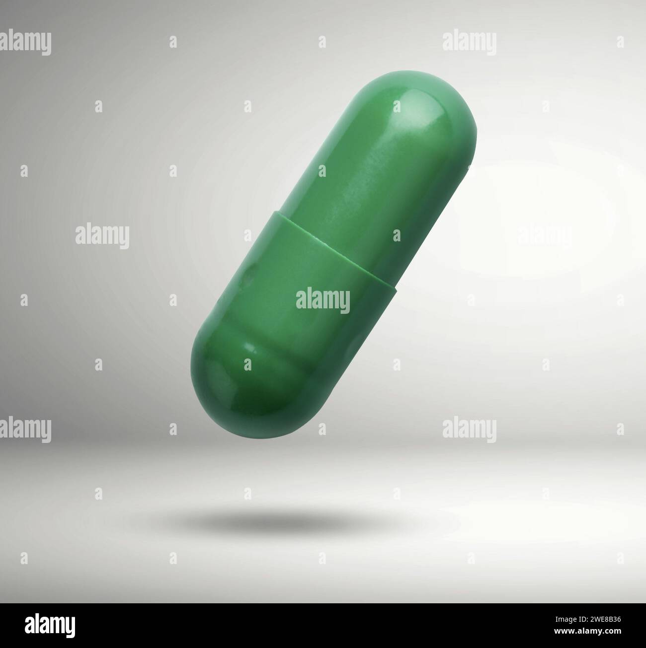 Green vitamin capsule in air on light grey background Stock Photo - Alamy