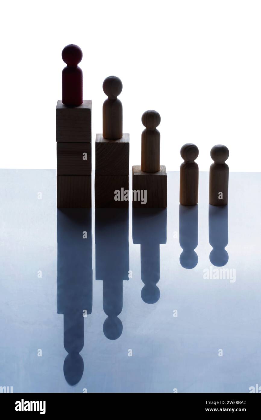 Closeup view of red wooden figures standing higher on a wooden cube ...