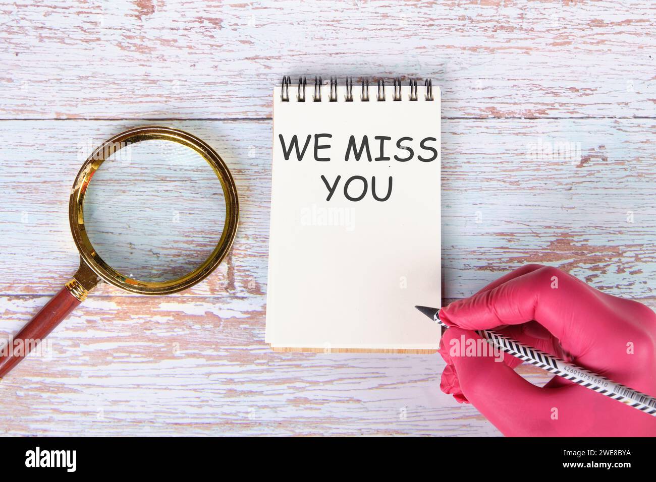 WE MISS YOU writing on a notebook lying on old boards next to a ...