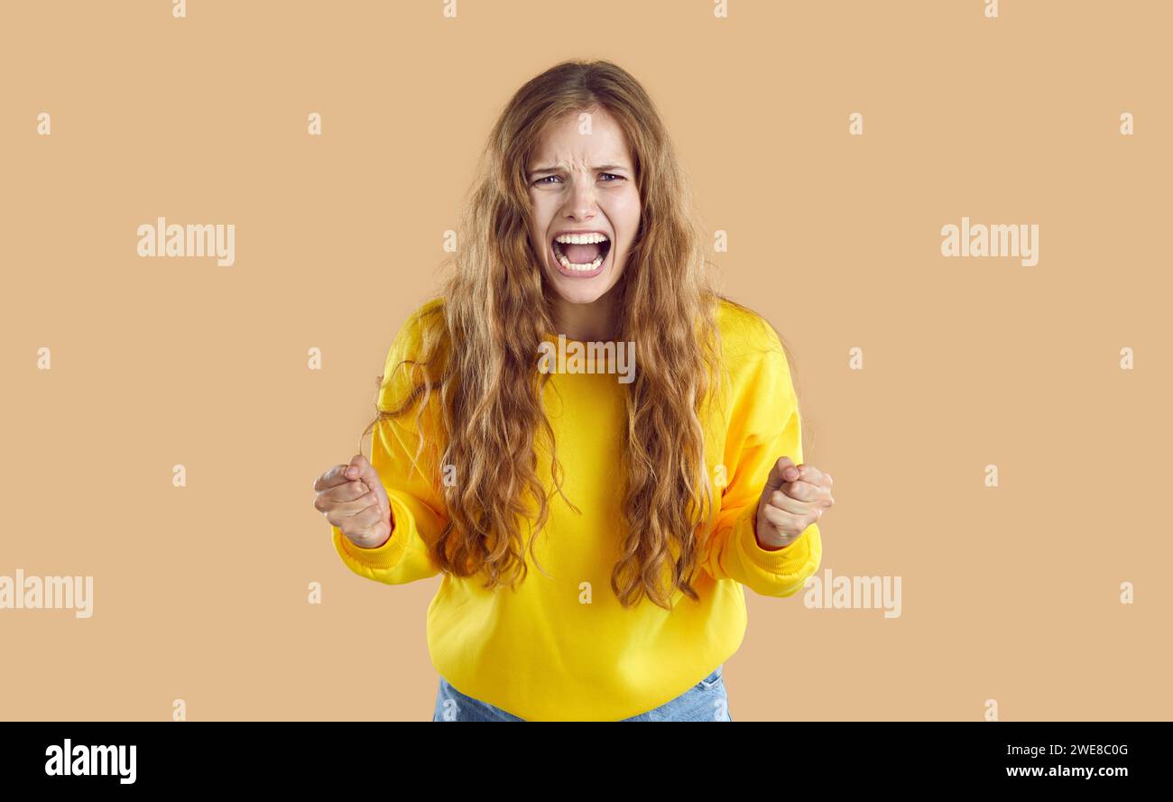 Frustrated emotional angry sad screaming young woman with clenched ...