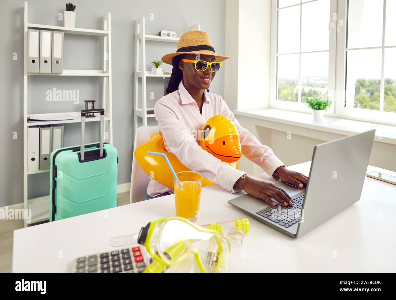 Funny woman sitting at the desk on workplace at office and booking ...