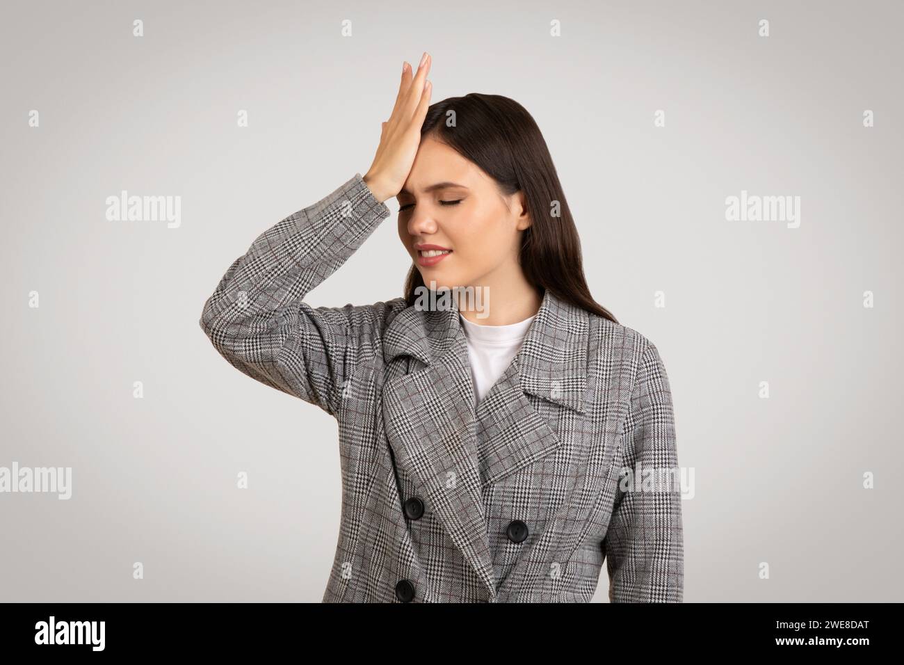 Regretful woman with hand on forehead, eyes closed in dismay Stock ...
