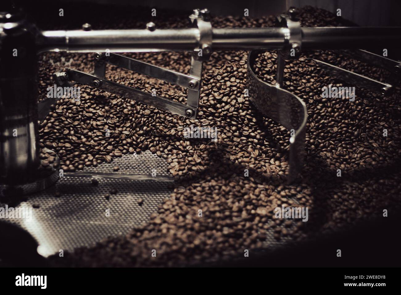 Close up of beans in a stainless steel industrial coffee roaster for an ...
