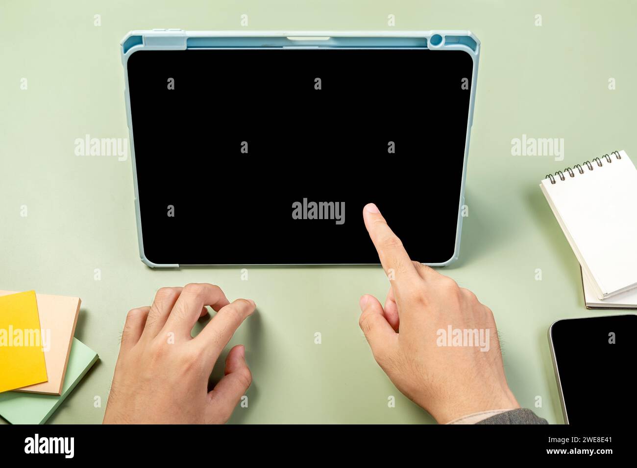 People hand use a tablet with a blank screen on a colored background ...