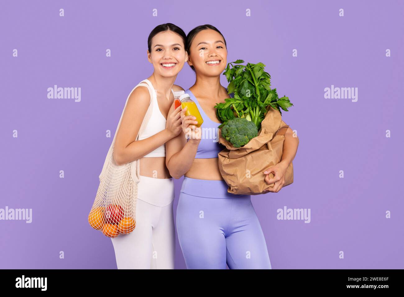 Happy diverse women with fresh produce and juice promoting healthy ...