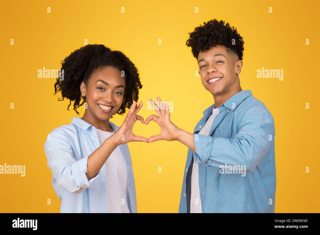 Affectionate young African American couple forming a heart shape with ...