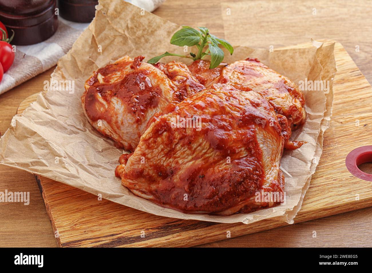 Marinated chicken leg thighs in tomato sauce Stock Photo - Alamy