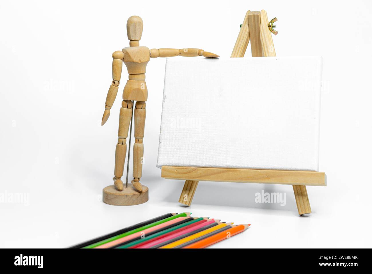 Wooden doll with empty easel on white background; business or creative ...