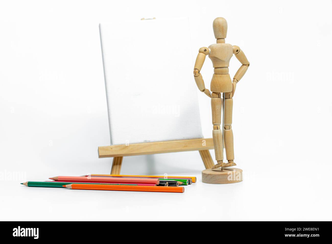 Wooden doll with empty easel on white background; business or creative ...