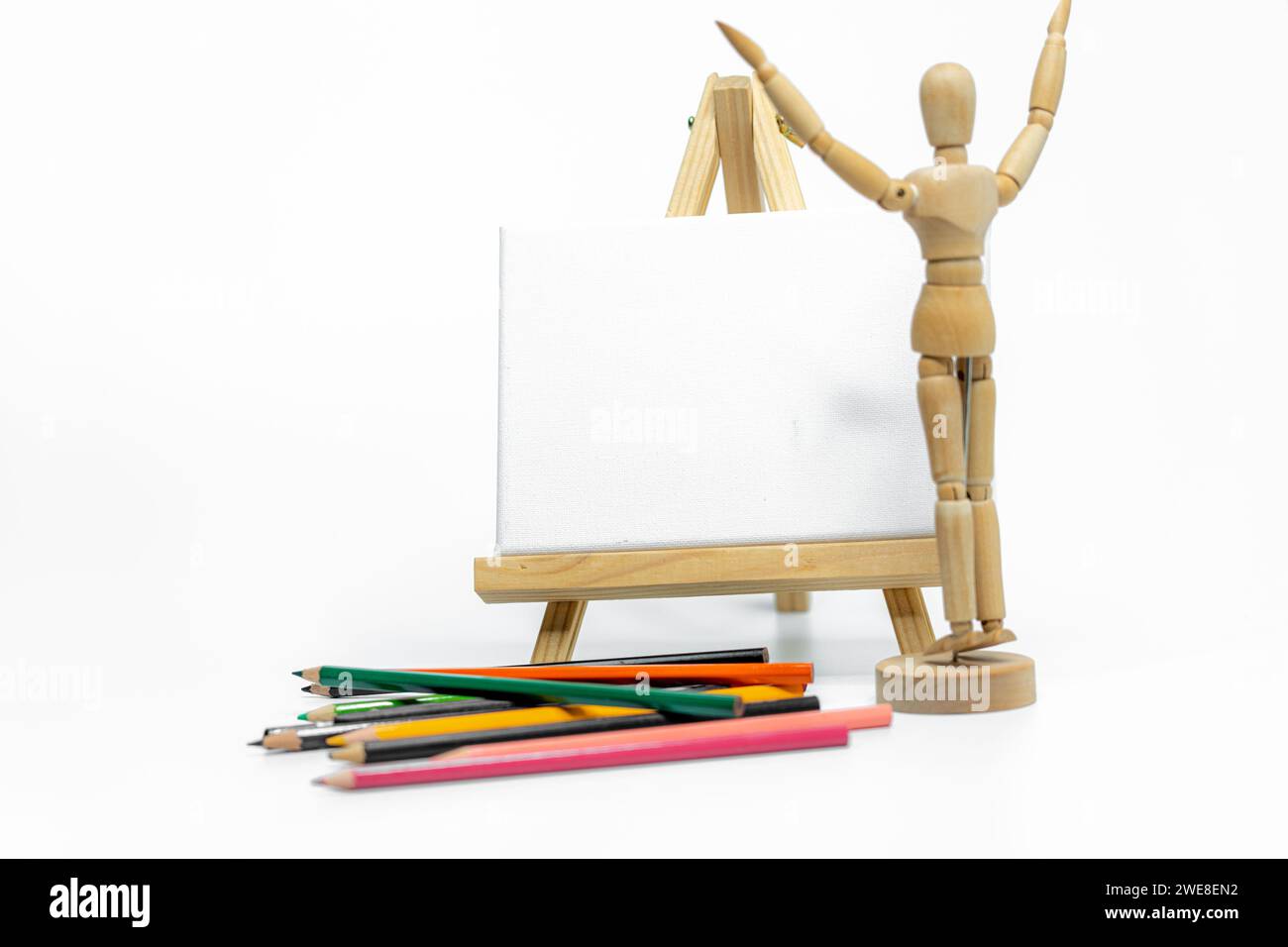 Wooden doll with empty easel on white background; business or creative ...