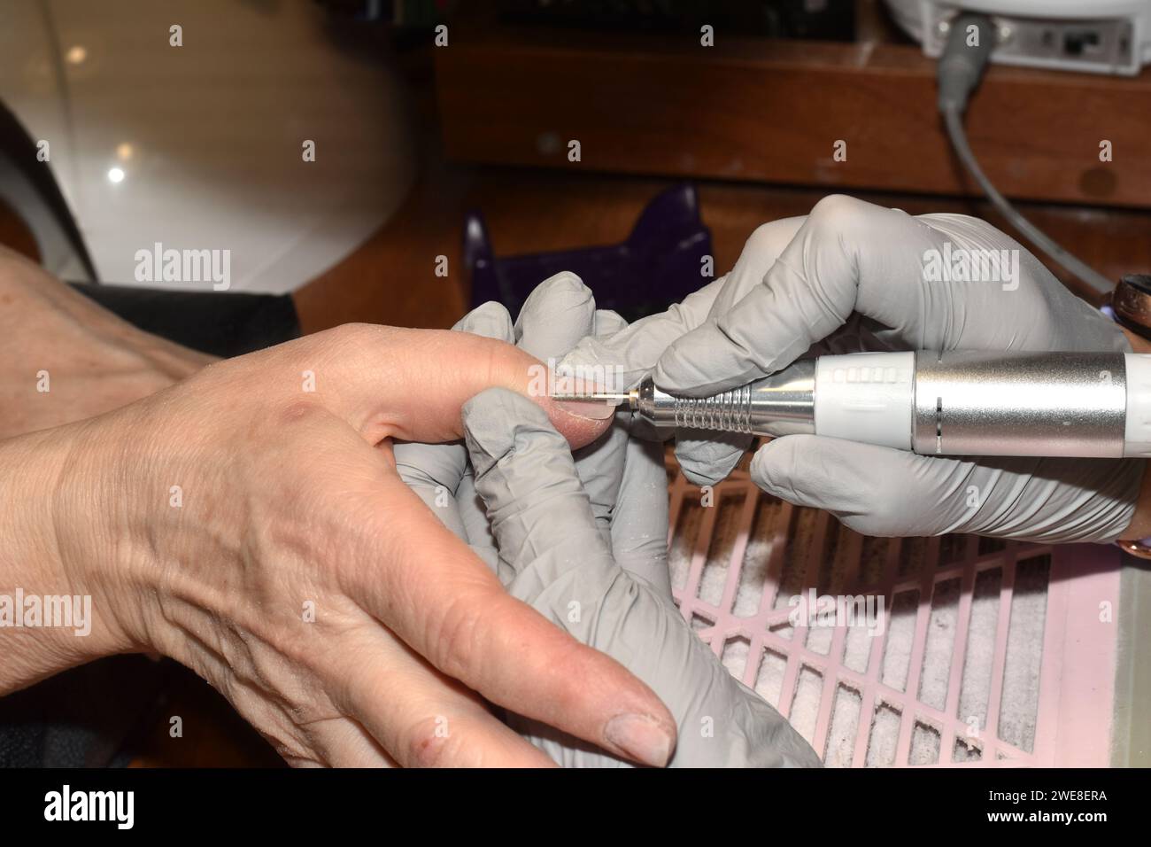 A manicurist uses a milling cutter to shape the shape and appearance of ...