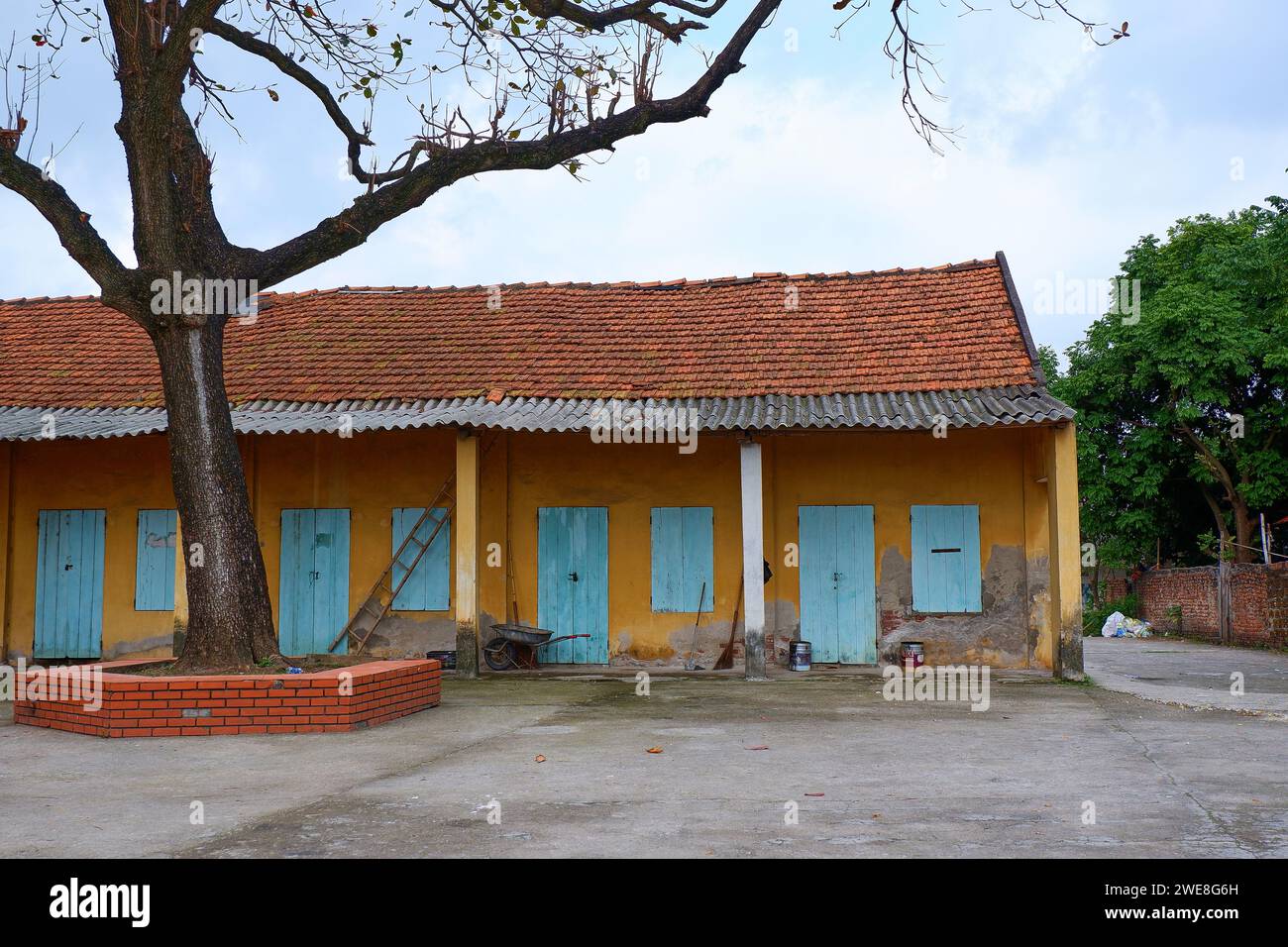 Rustic old yellow building surrounded by nature Stock Photo - Alamy