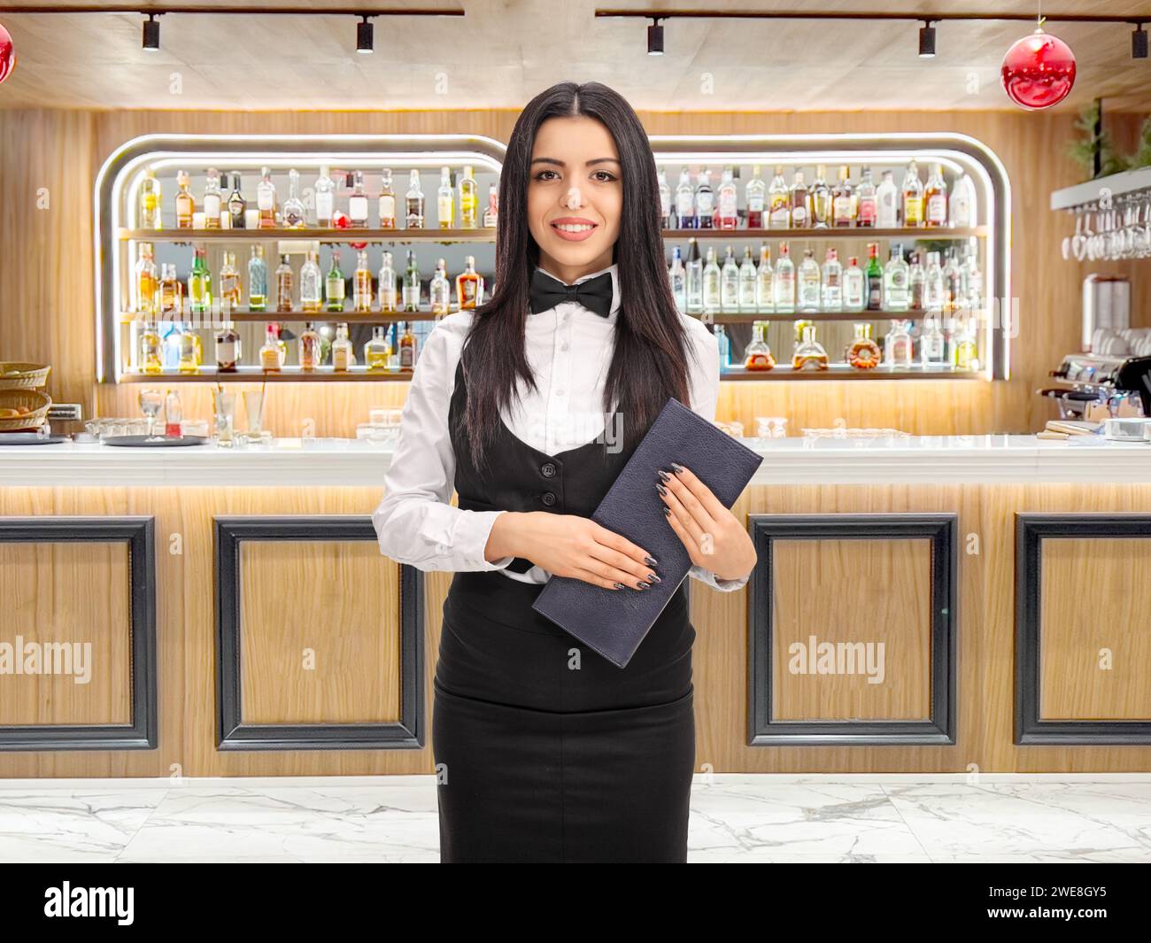 Waitress holding a menu and standing by a bar Stock Photo - Alamy