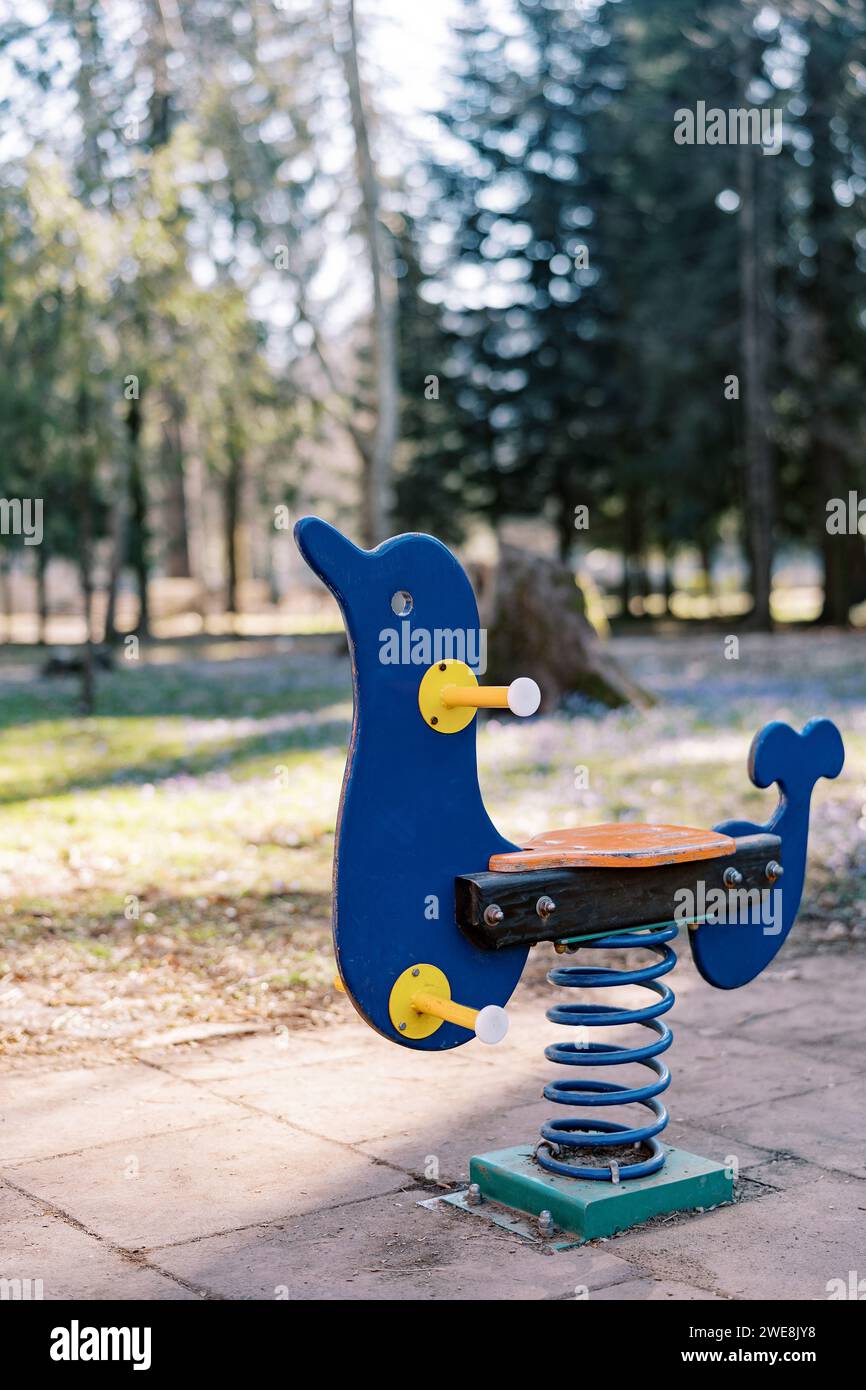 Spring swing with wooden handles stands on a rubber flooring in a ...