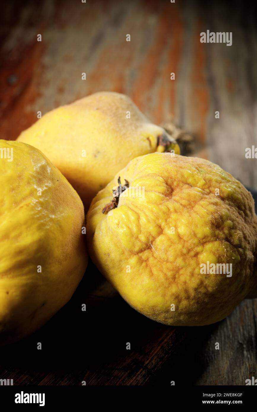Close up of a group of fruit quinces on a wood table Stock Photo - Alamy