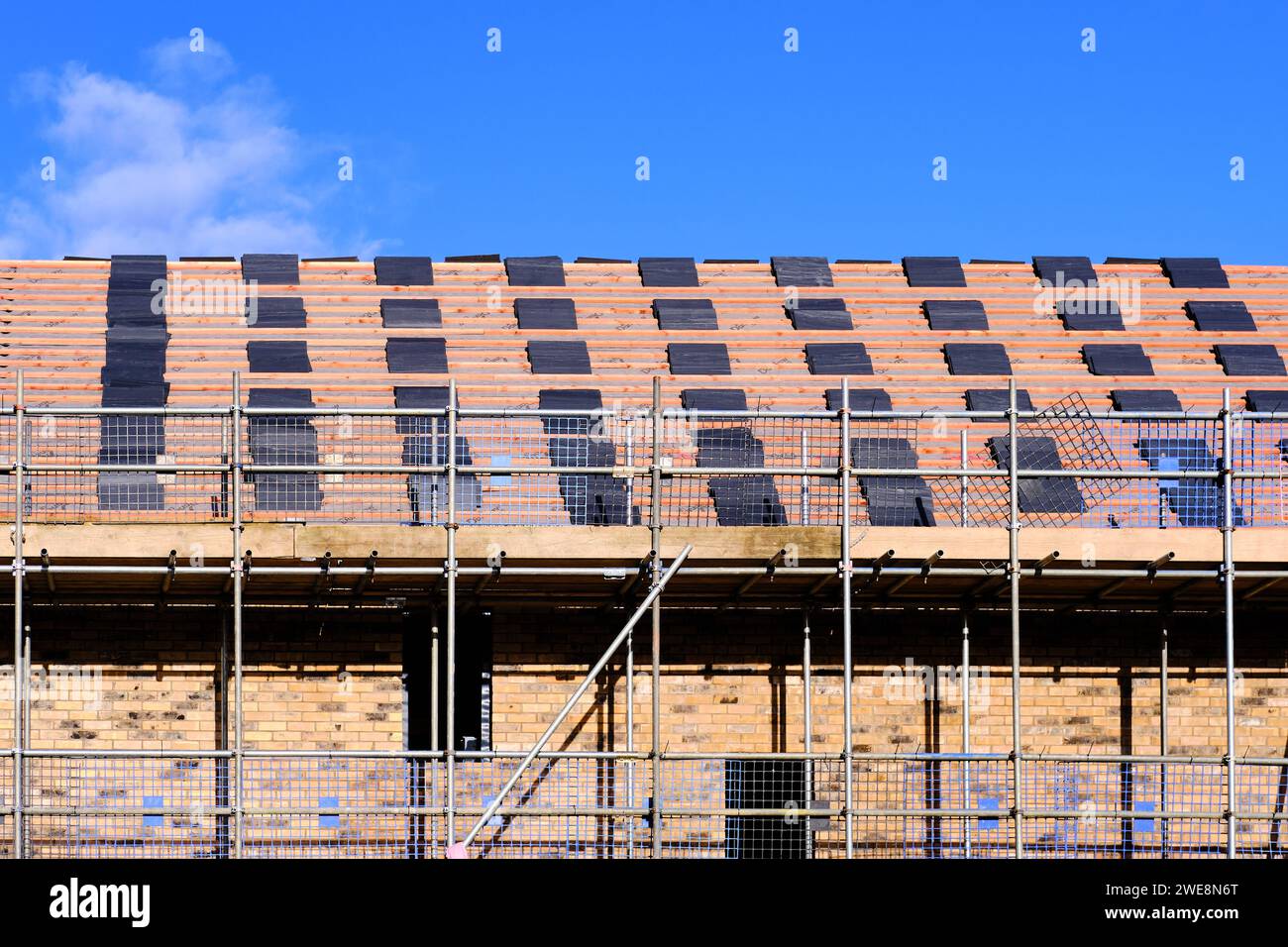 tiles stacked and ready for laying on the roof of a house under ...
