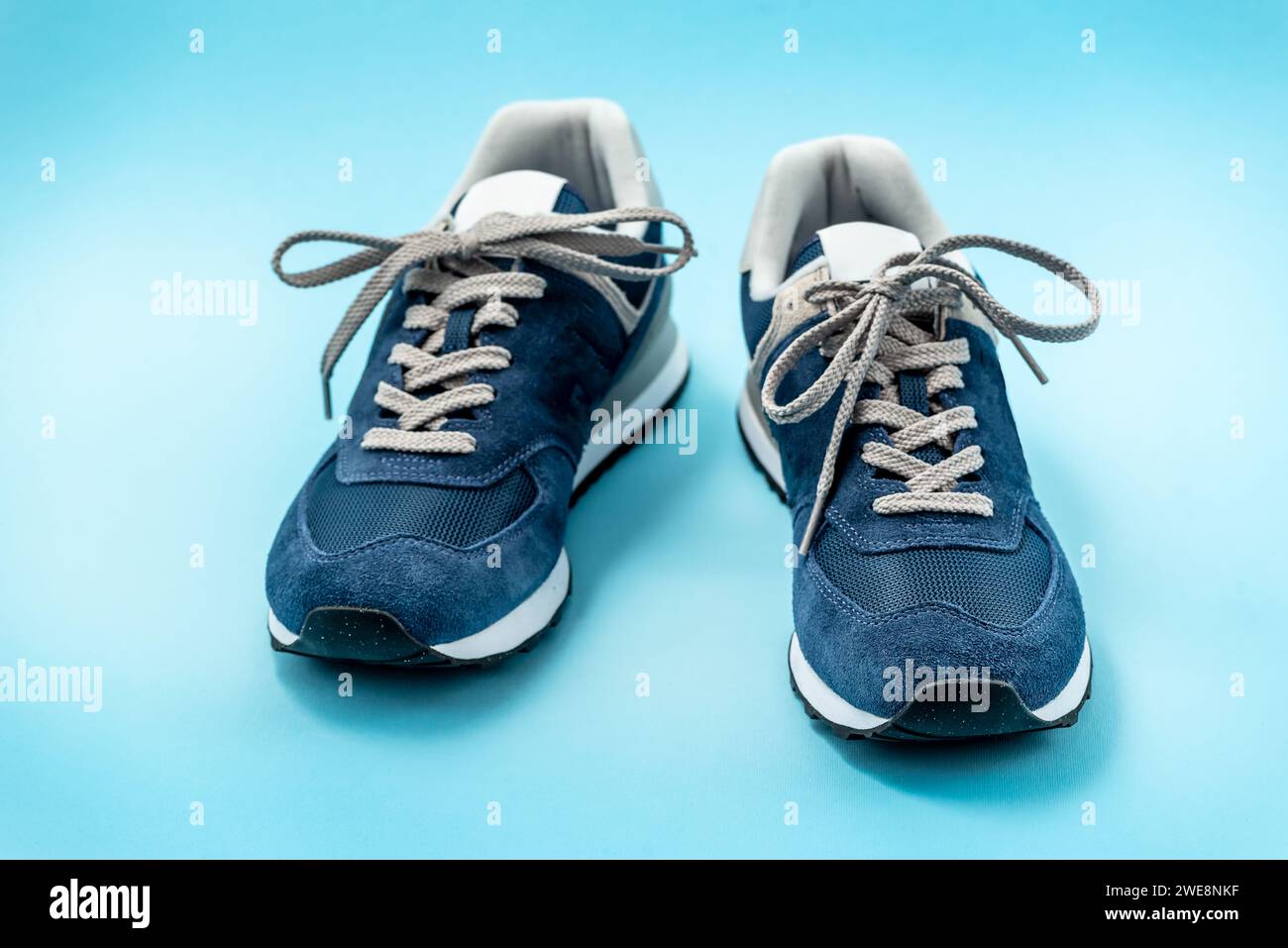 Blue leather sneakers isolated on light blue background Stock Photo - Alamy