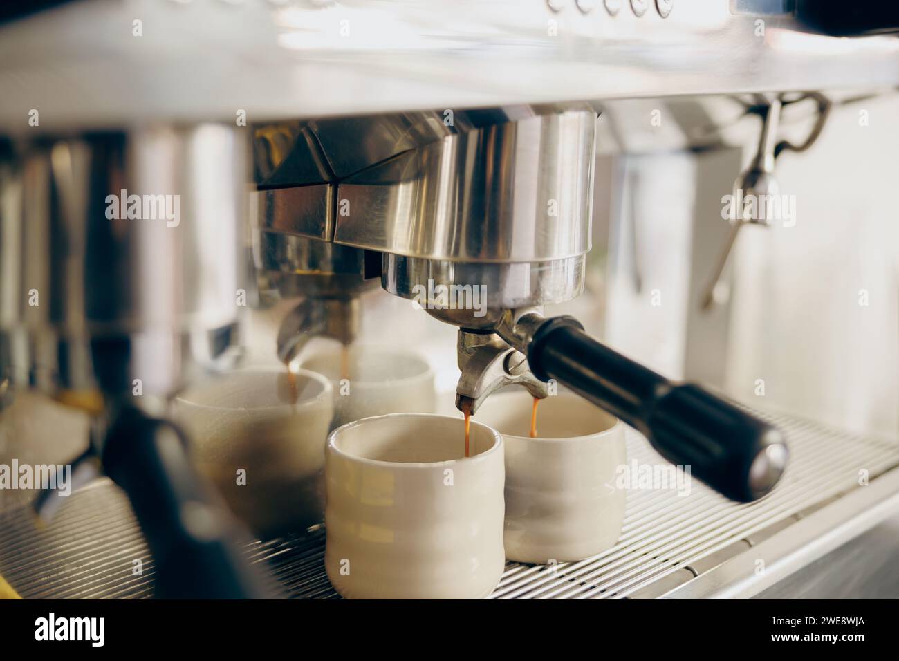 Coffee machine filling a two cups with espresso in professional coffee ...