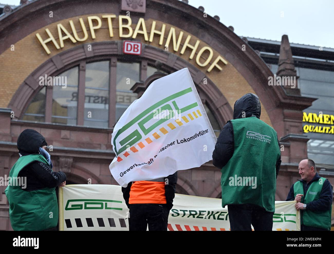 Erfurt, Germany. 24th Jan, 2024. Union members stand with a flag and ...
