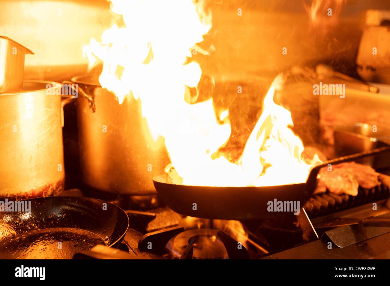 Chef cooking with a flaming pan, displaying their culinary skills Stock ...