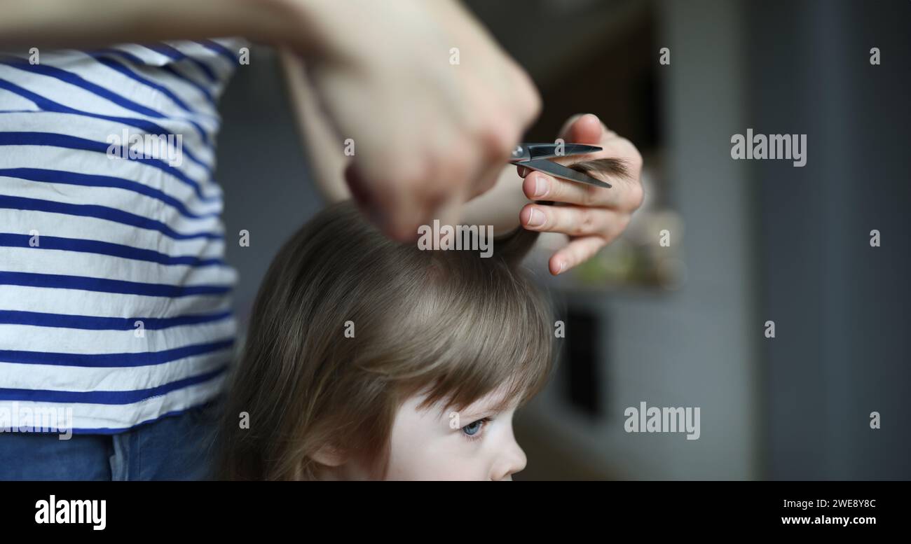 Woman doing haircut to child in an apartment Stock Photo - Alamy