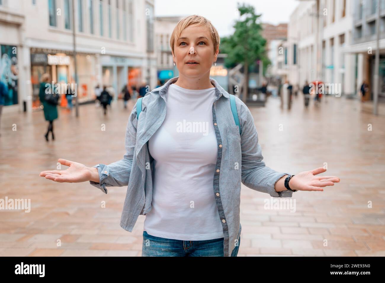a confused woman in blue shirt with backpack with coffee under a ...