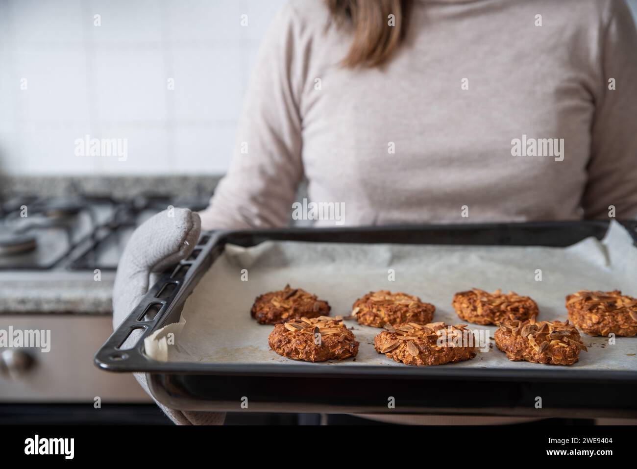 Woman holding baking tray with ready cookies Stock Photo - Alamy