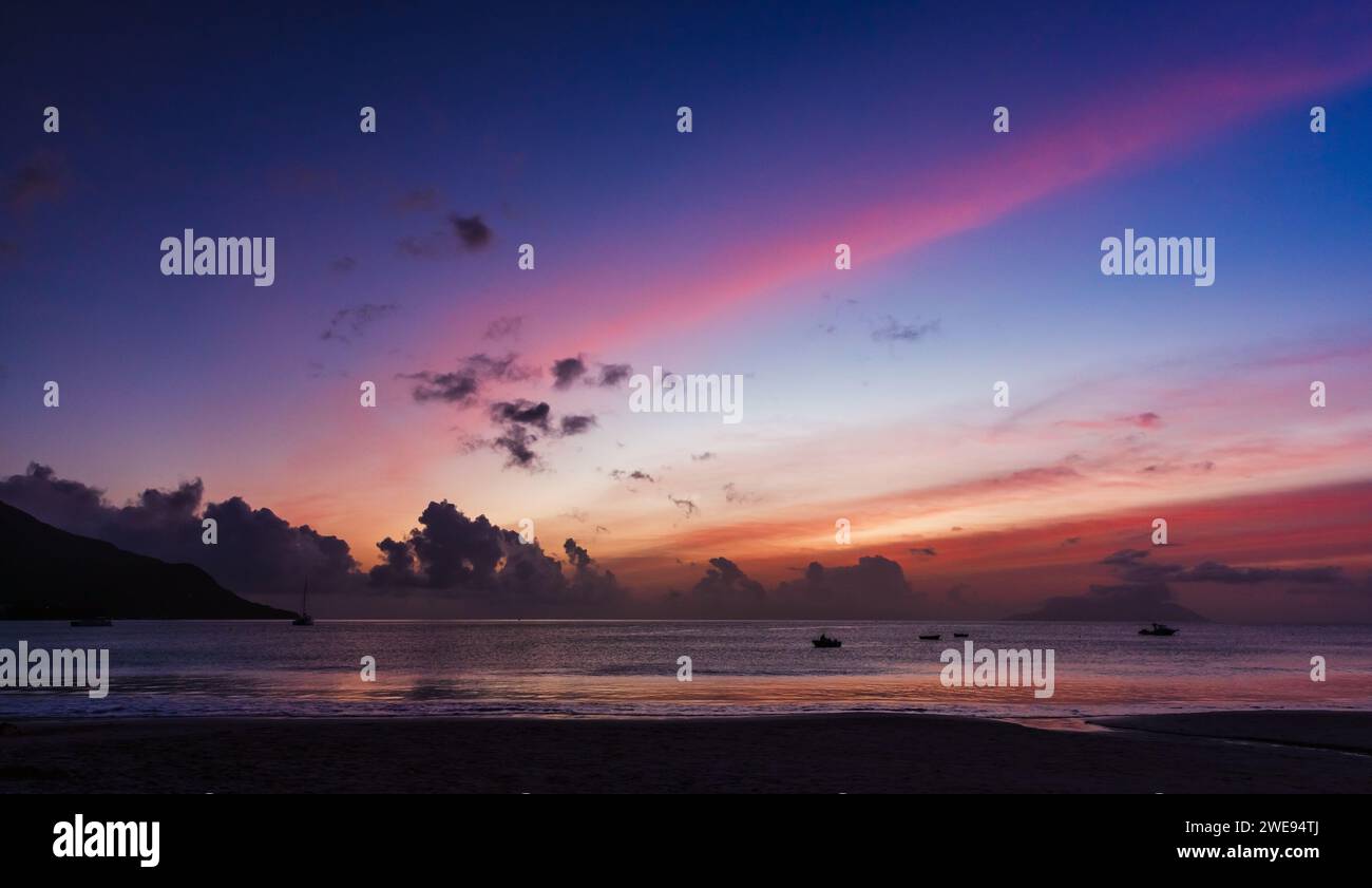 Seychelles landscape, ocean shore water under colorful sky at sunset ...