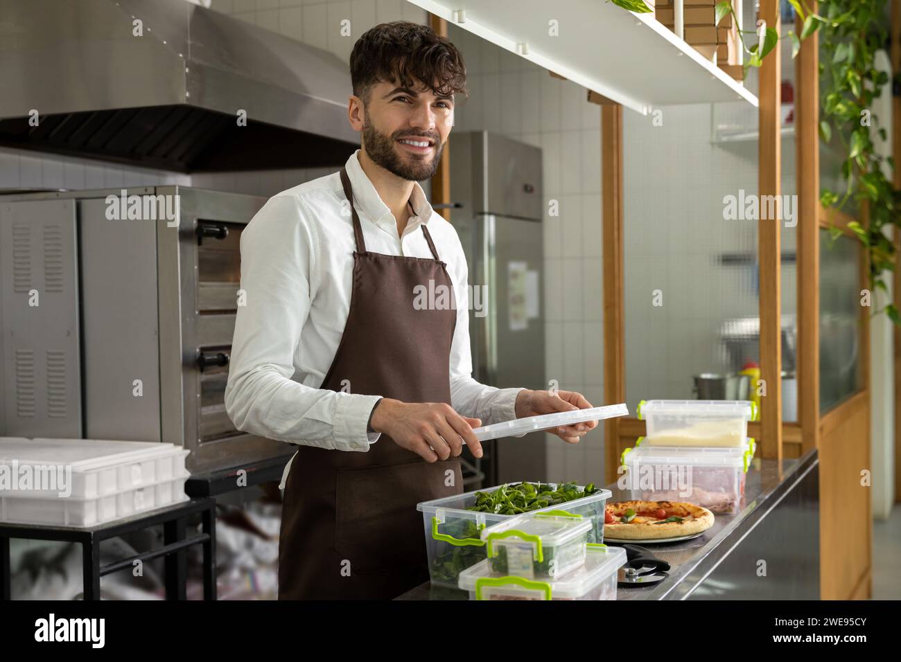 Pizzeria worker with food boxes in hands Stock Photo - Alamy
