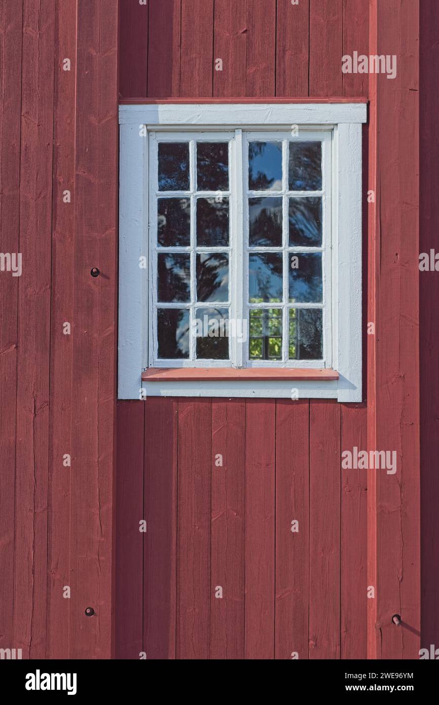 White painted wood framed window on a old red painted wooden building ...