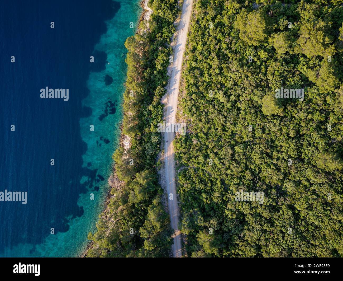 Aerial viewpoint of a road next to the sea during sunset. Travel ...