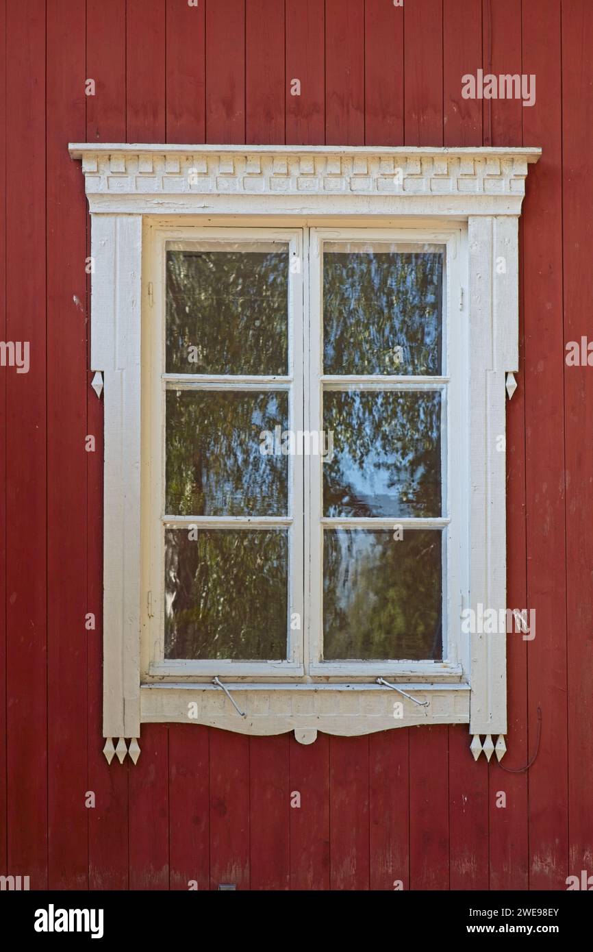 Old white painted wood framed window on a red painted wooden building ...