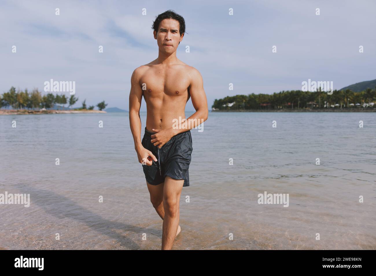 Active Asian Athlete Running on the Beach: Fit, Muscular Man Exercising ...