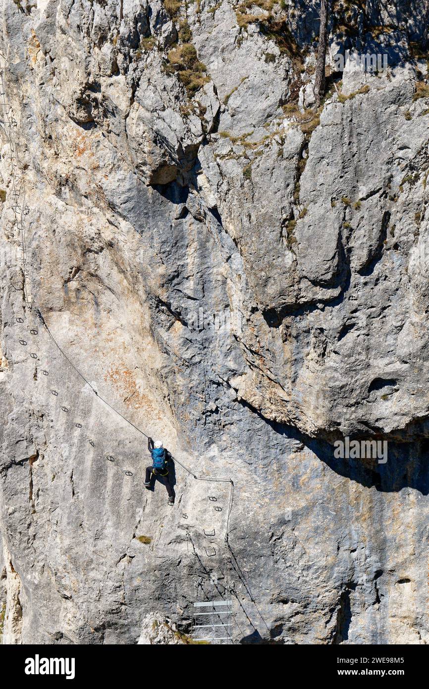 A person climbing via ferrata on a vertical rock wall. Sports life in ...