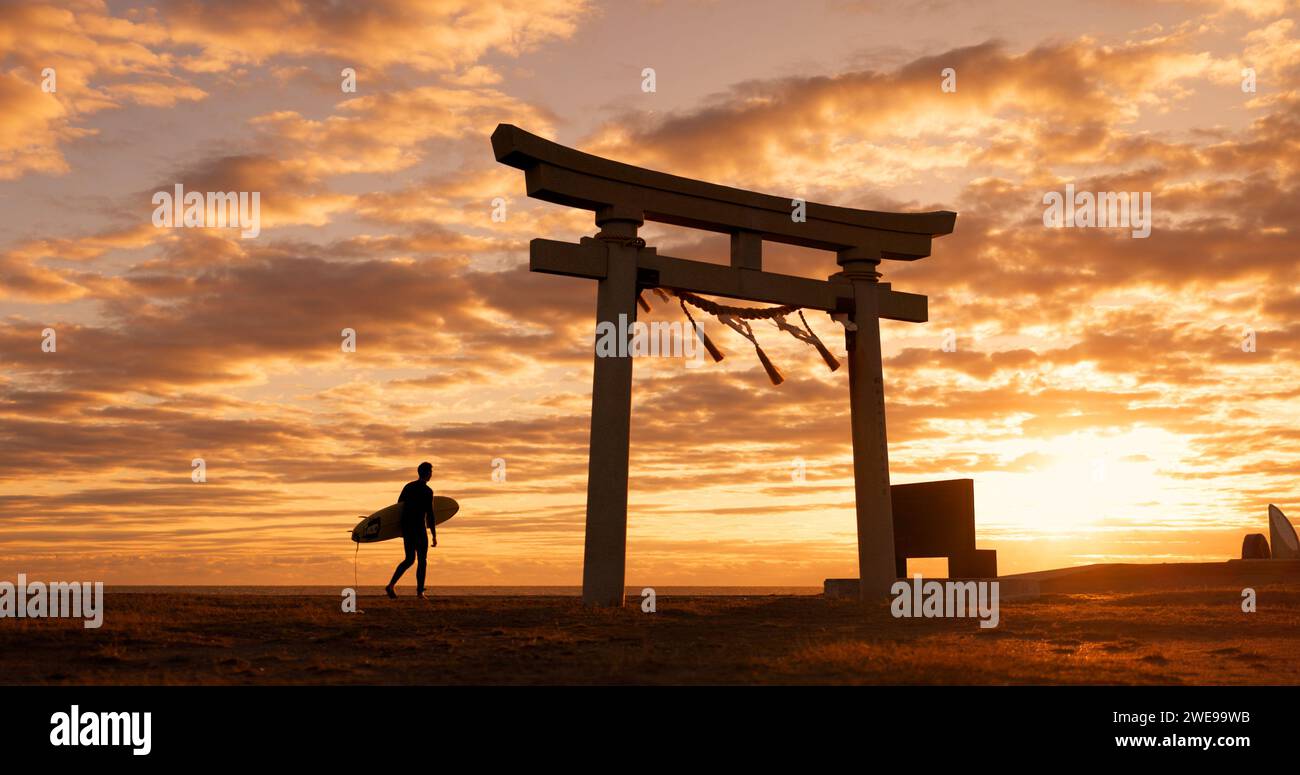 Torii gate, sunset and man with surfboard, ocean and travel adventure ...