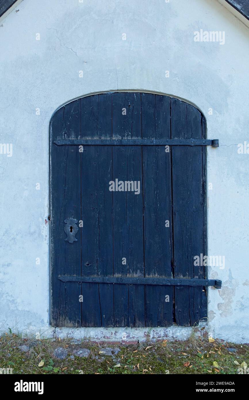 Black wood door to a crypt on a old white stone building Stock Photo ...