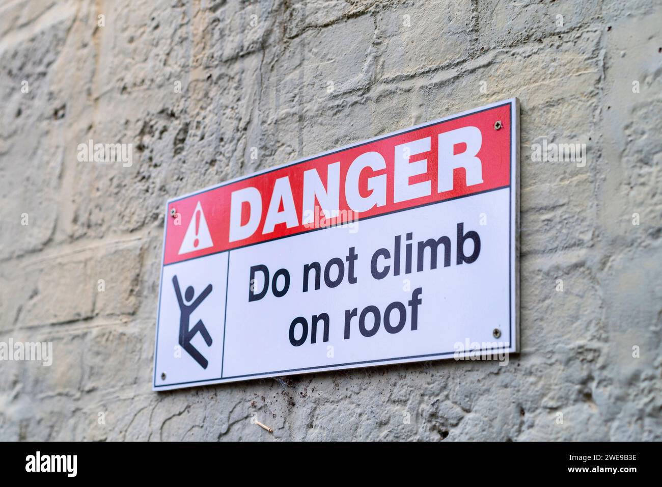 Close up of warning notice in situ on outdoor wall advising public ...