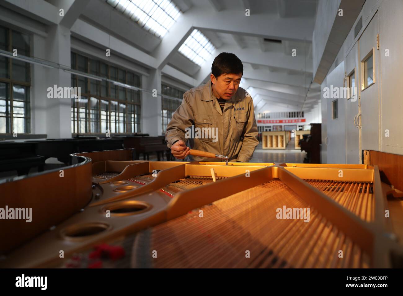 (240124) -- SHENYANG, Jan. 24, 2024 (Xinhua) -- Zhang Yongqing tunes a ...