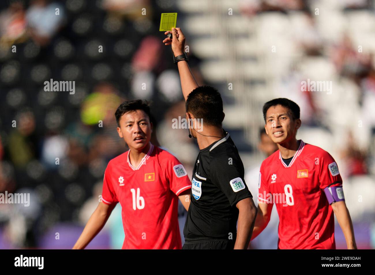 Referee Muhammad Nazmi bin Nasaruddin shows a yellow card to Vietnam's ...